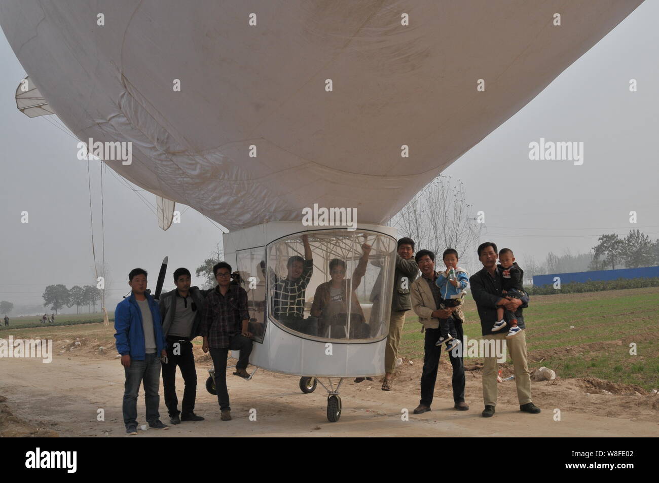 Local villagers pose with the zeppelin made by Chinese farmer Shi ...