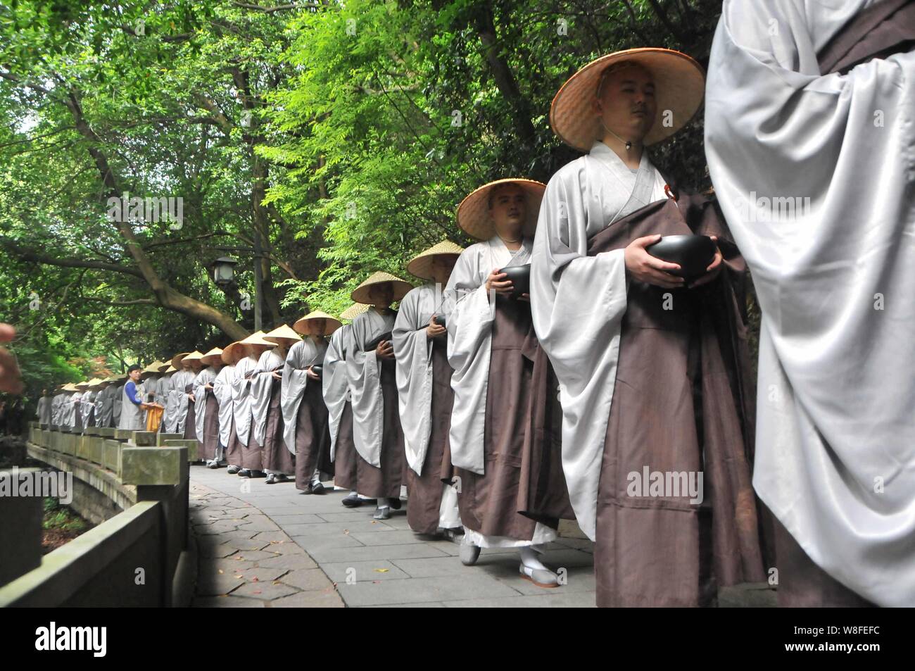 Chinese Buddhist monks holding alms bowls take part in a mendicants ...