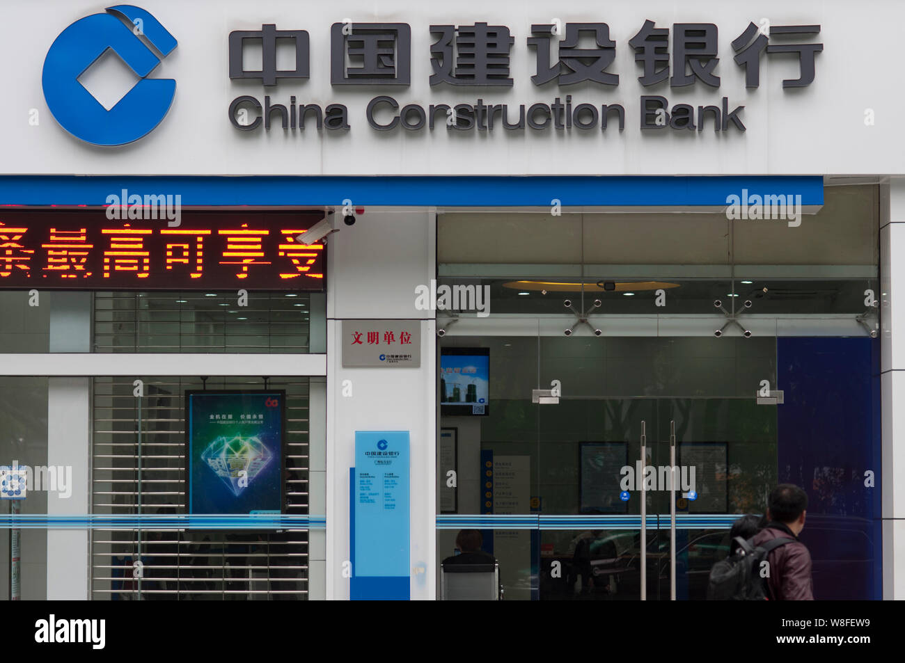 Pedestrians walk past a branch of China Construction Bank (CCB) in ...