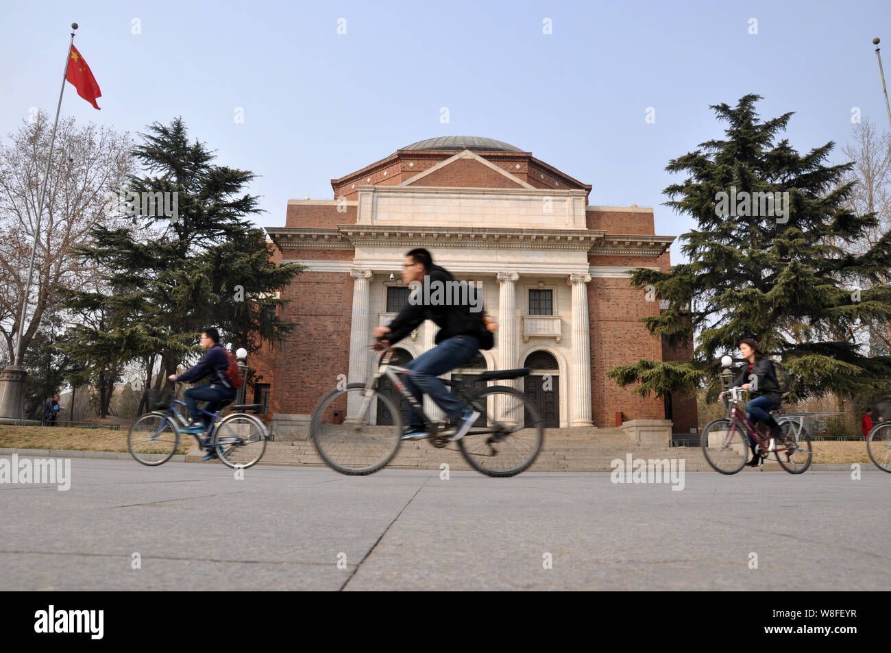 --FILE--Chinese students cycle past a school building on the campus of ...