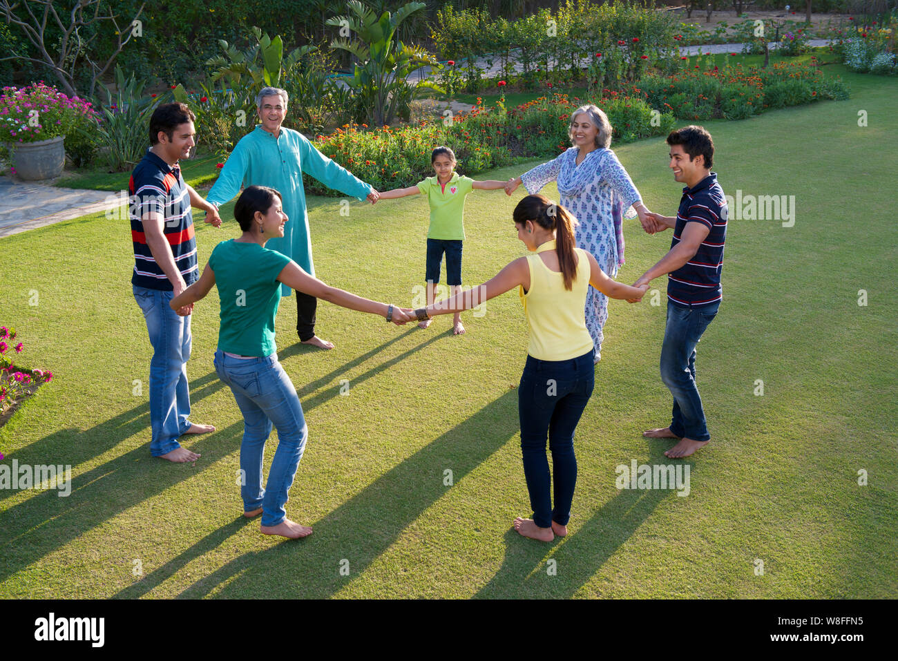 Family playing ring around the rosie in a park Stock Photo - Alamy