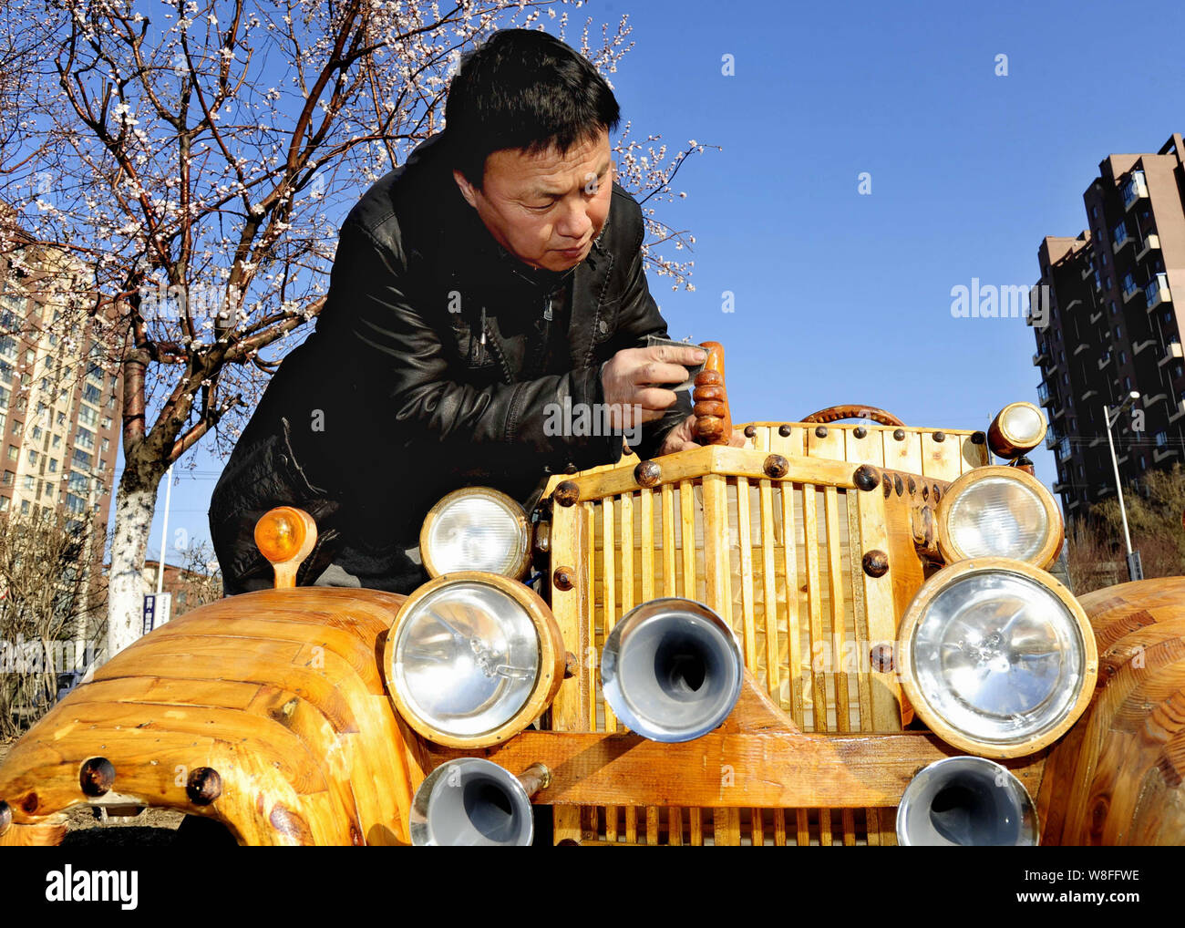 Chinese carpenter Liu Fulong dusts off the logo of his third homemade ...