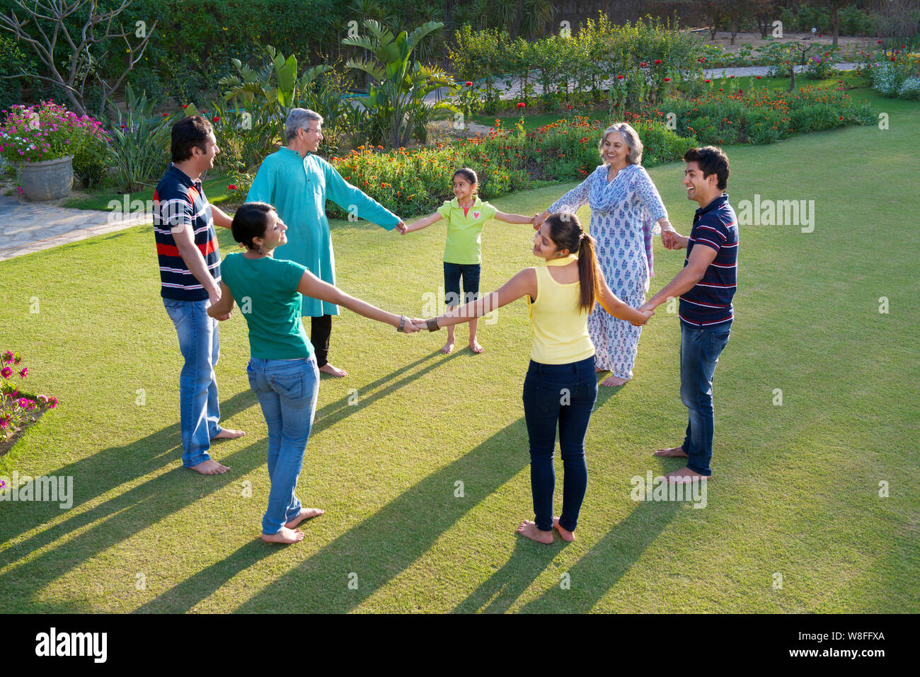 Family playing ring around the rosie in a park Stock Photo - Alamy