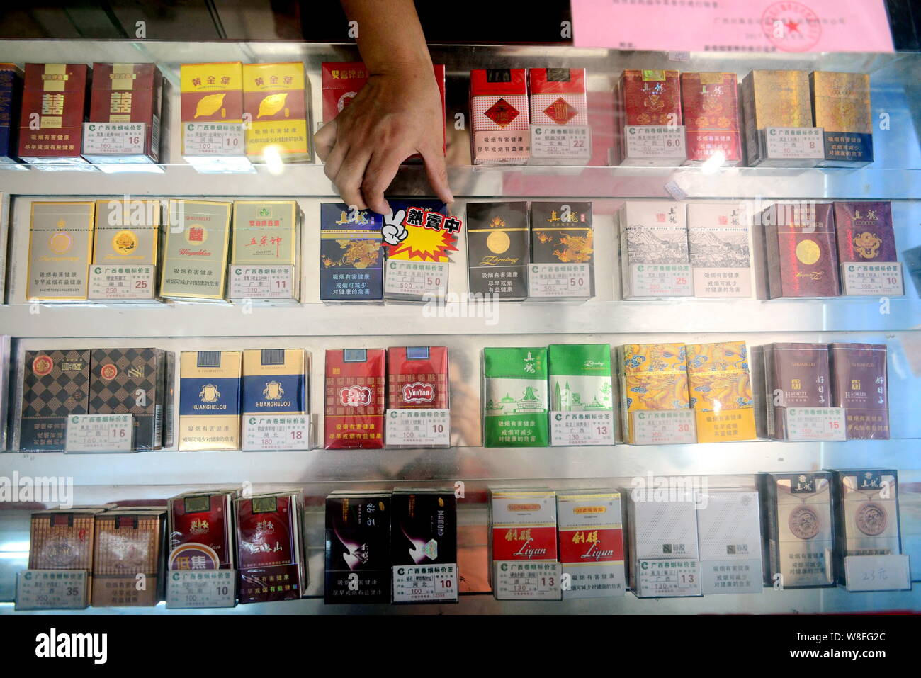 A Chinese clerk sells cigarettes at a tobacco store in Hezhou city ...