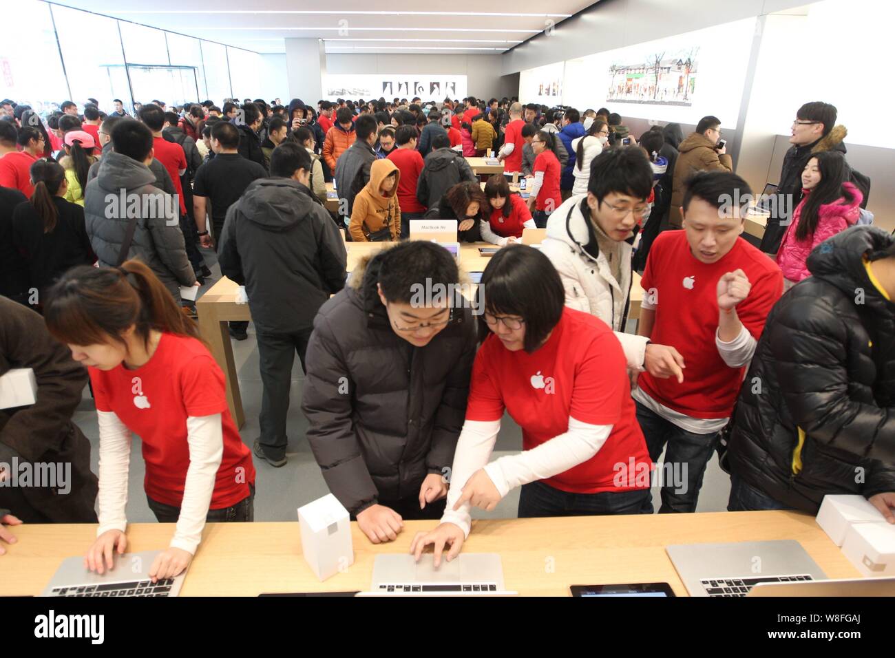 Chinese employees introduce Apple laptop computers to customers at the ...