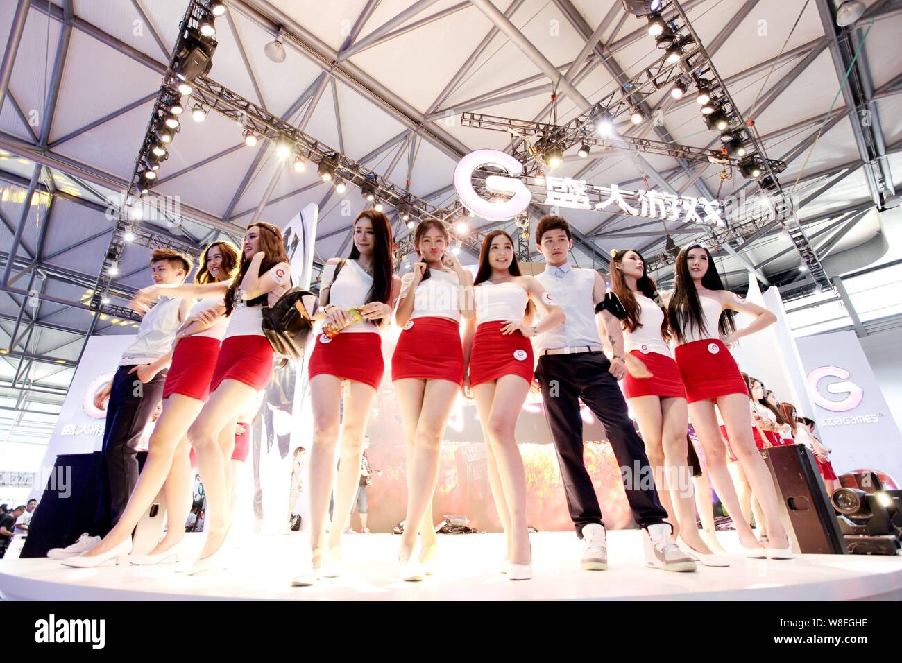 Showgirls and models pose at the stand of Shanda Games during the 13th ...