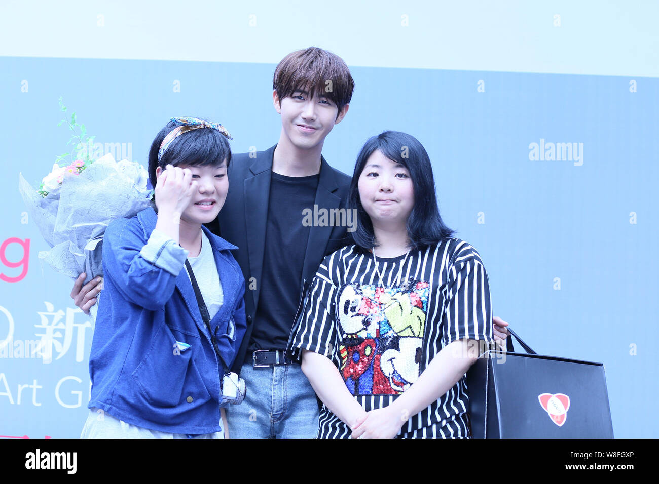 Hwang Kwang-hee of South Korean boyband ZE:A, center, poses with fans ...