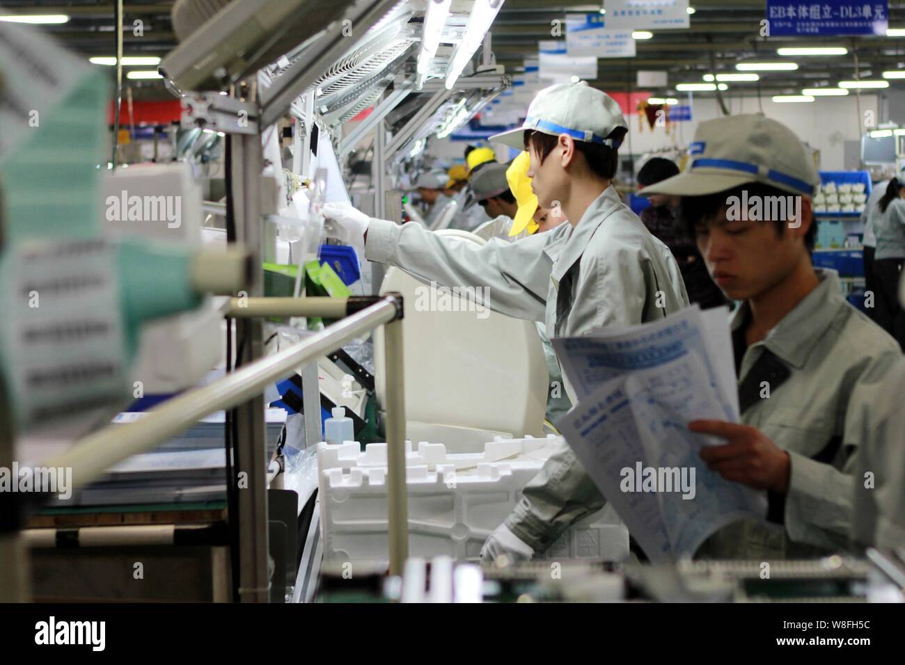Chinese workers assemble smart toilet seats on the assembly line at a ... Chinese workers assemble smart toilet seats on the assembly line at a ...