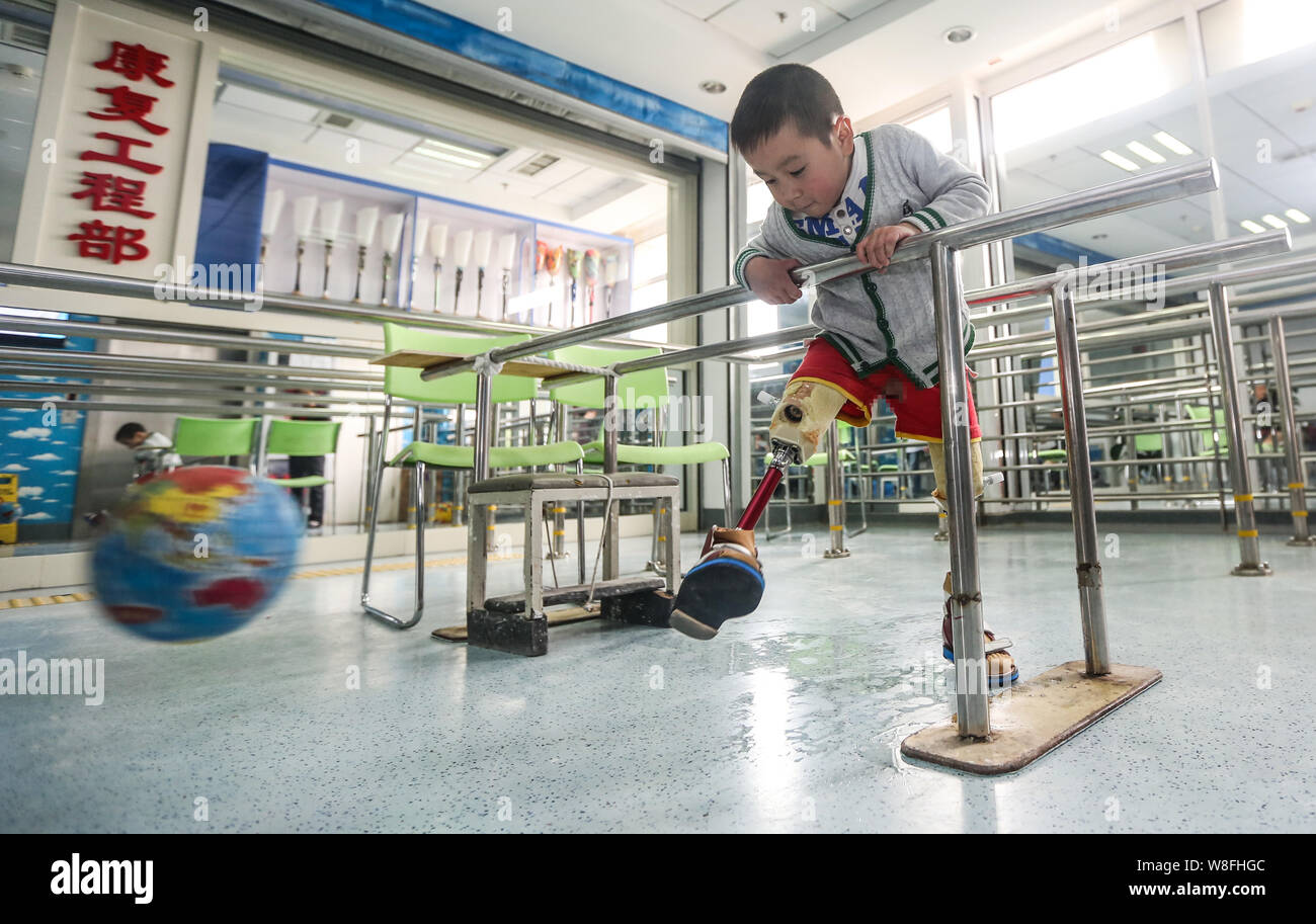 The four-year-old legless boy Xiao Feng kicks a ball with the aid of ...