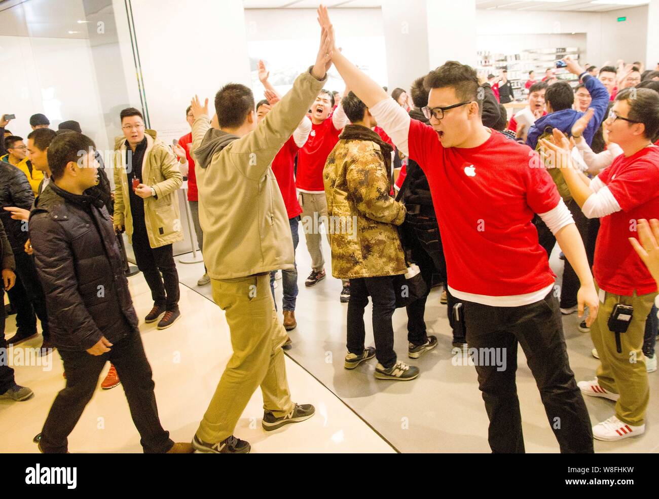 Chinese employees give high-five to greet customers inside the Apple ...