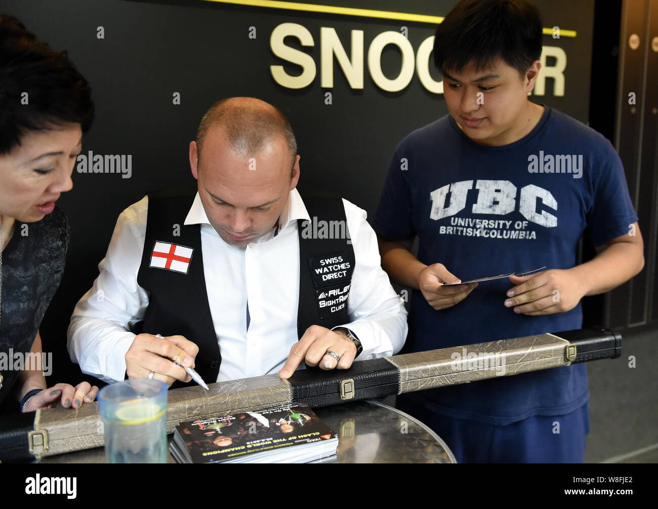 Stuart Bingham of England, center, signs an autograph at a fan meeting ...