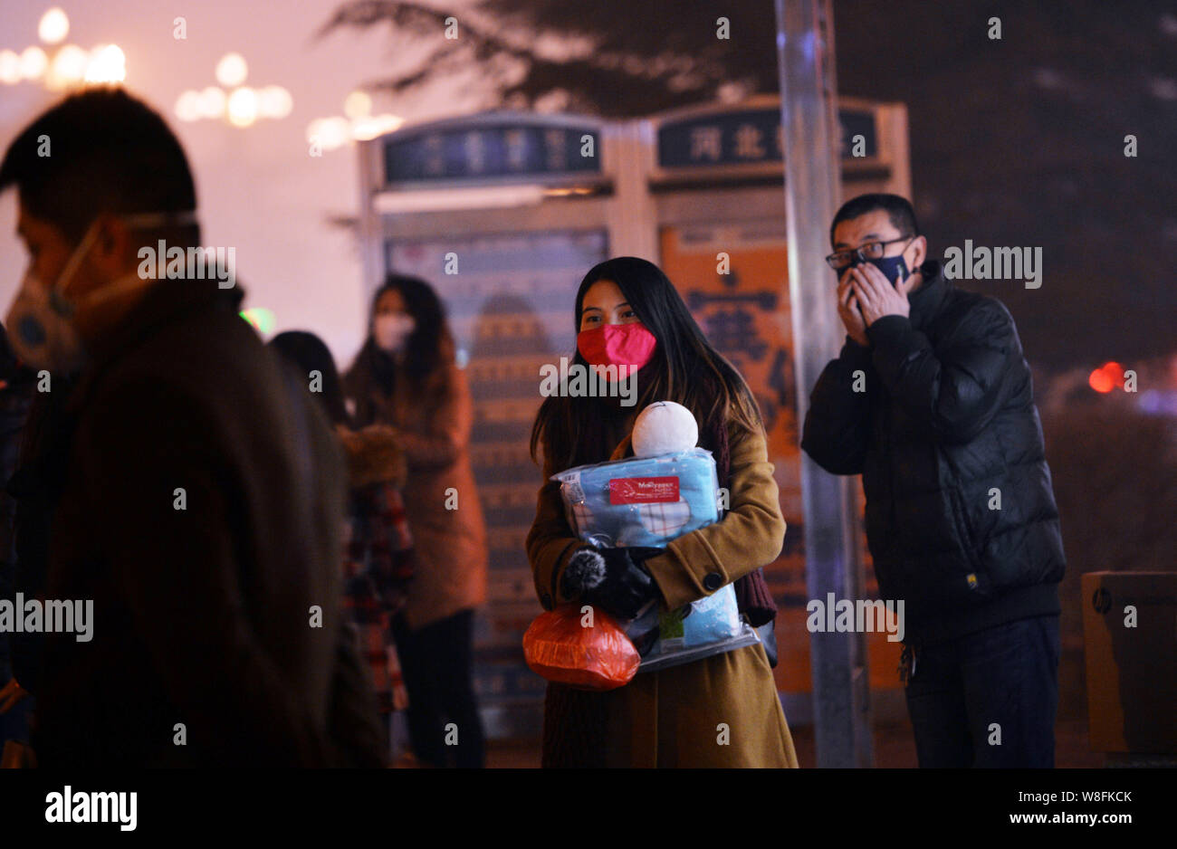 Chinese commuters wearing face masks against air pollution wait at a ...