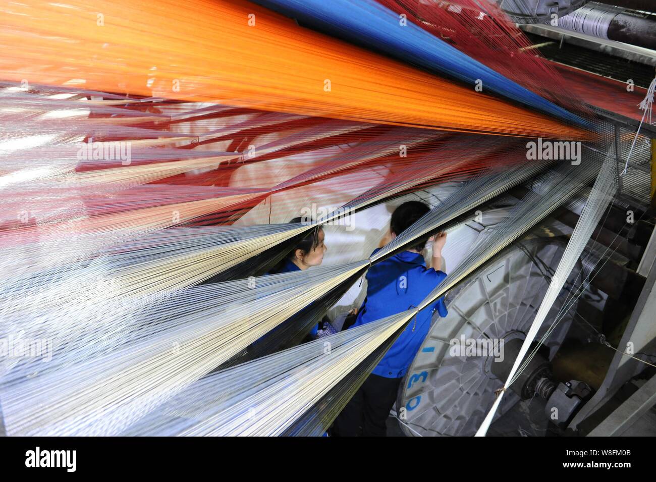 --FILE--Chinese workers handle production of yarn at a carpet factory ...
