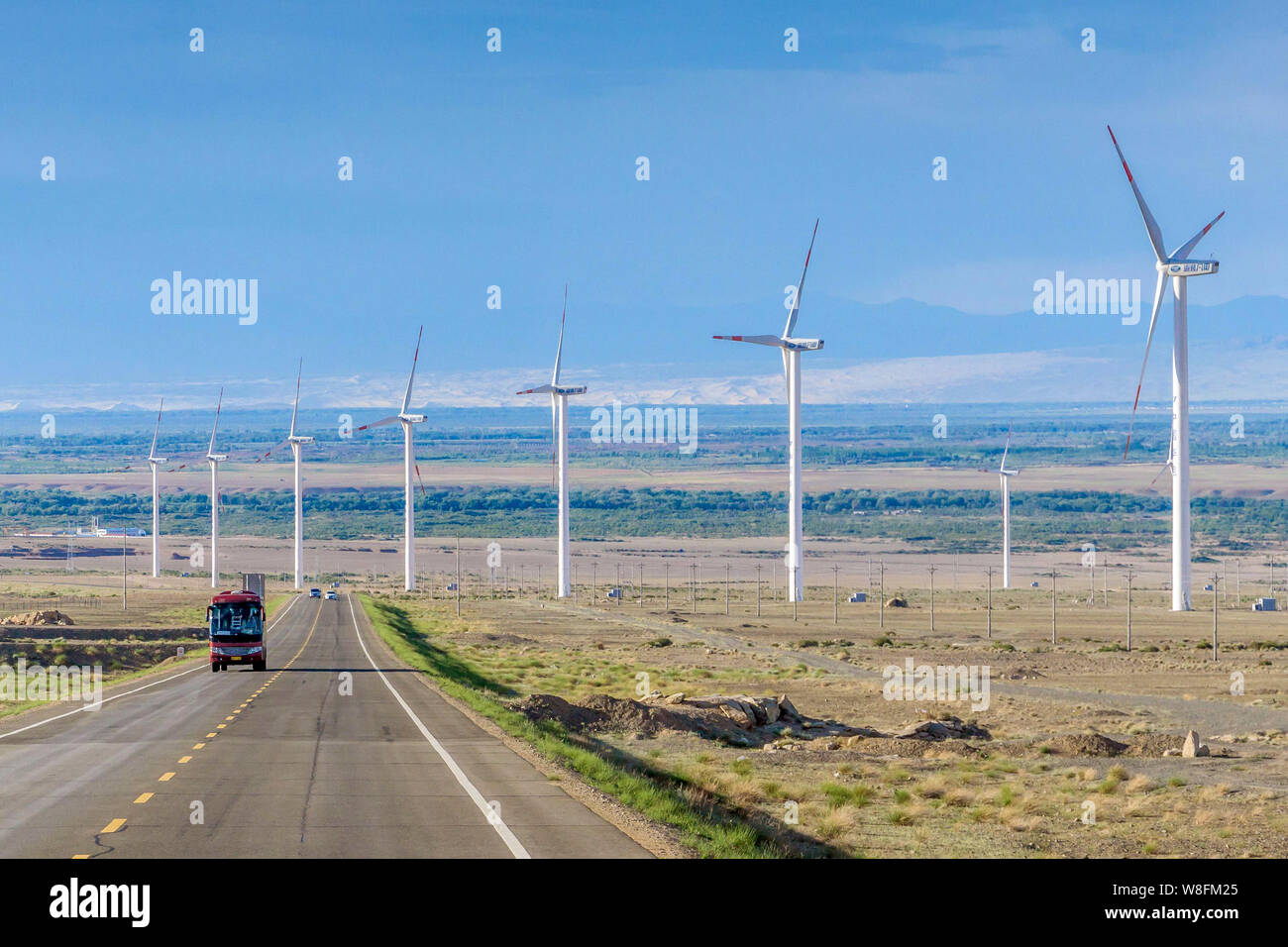 --FILE--Vehicles pass by wind turbines whirling to generate electricity ...