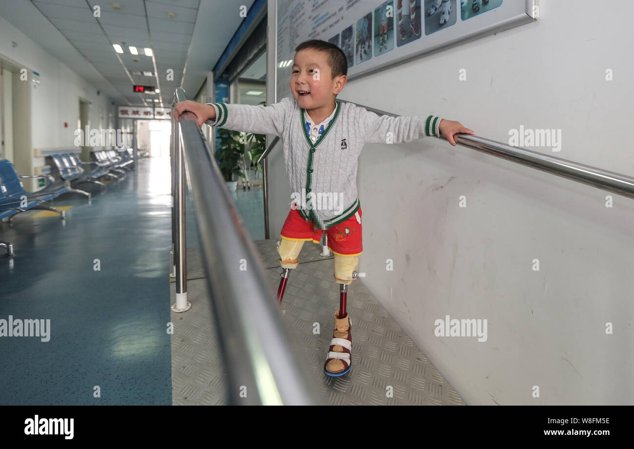The four-year-old legless boy Xiao Feng practices walking with the aid ...