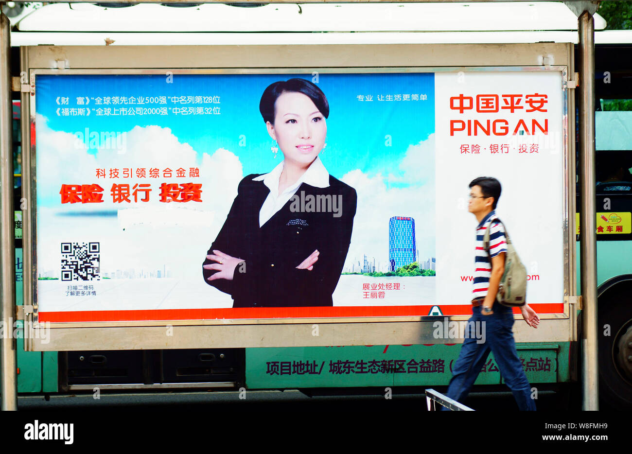 --FILE--A pedestrian walks past an advertisement of Ping An of China at ...