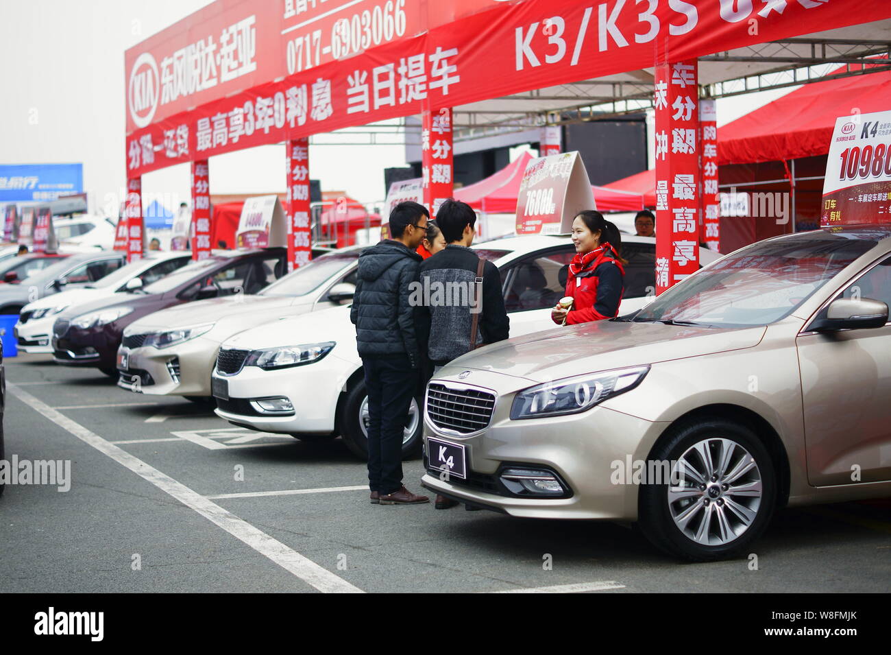 --FILE--Chinese visitors talk with a salesgirl of KIA cars during an ...