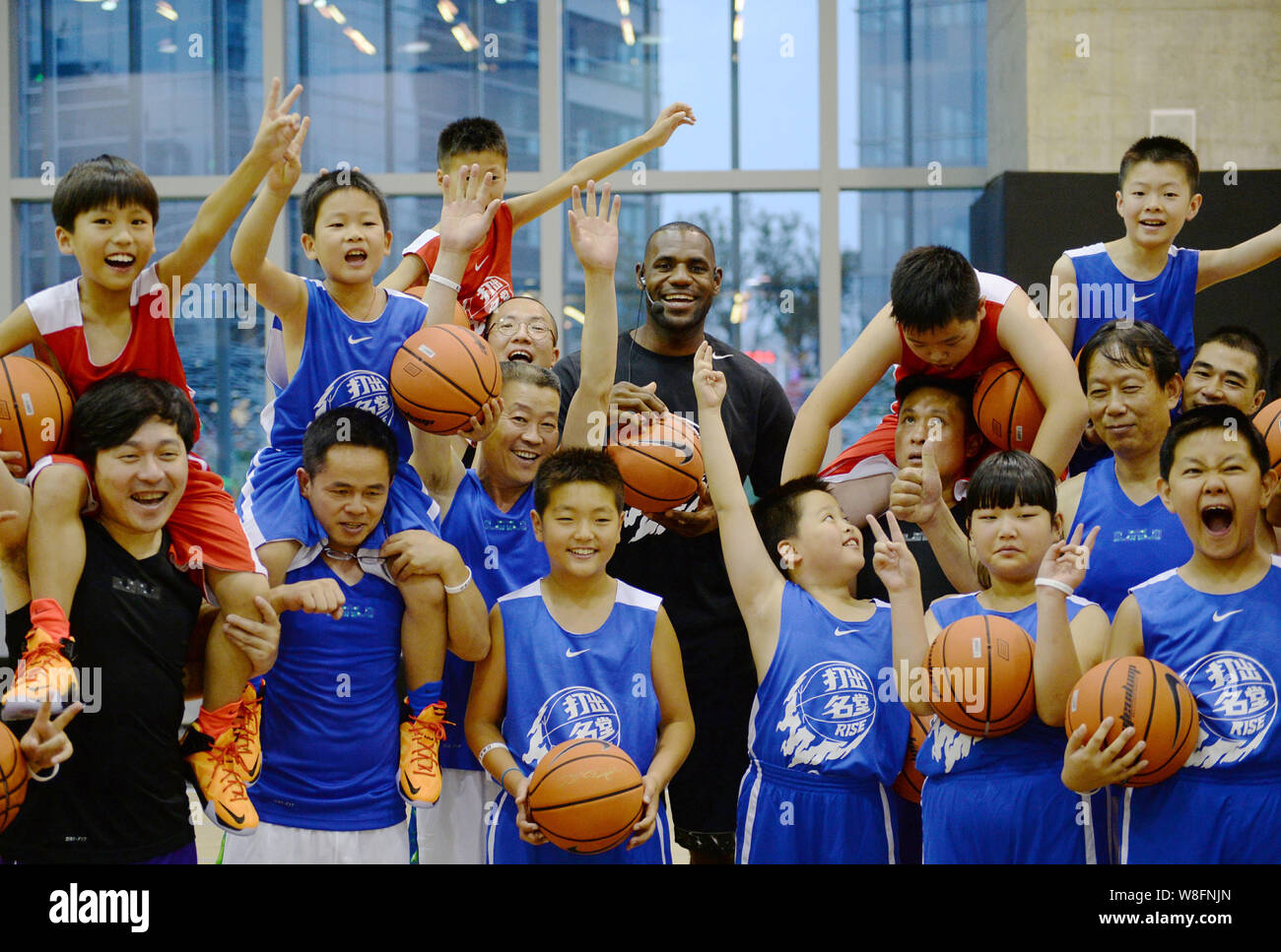 NBA star LeBron James, back center, poses with young Chinese kids and ...