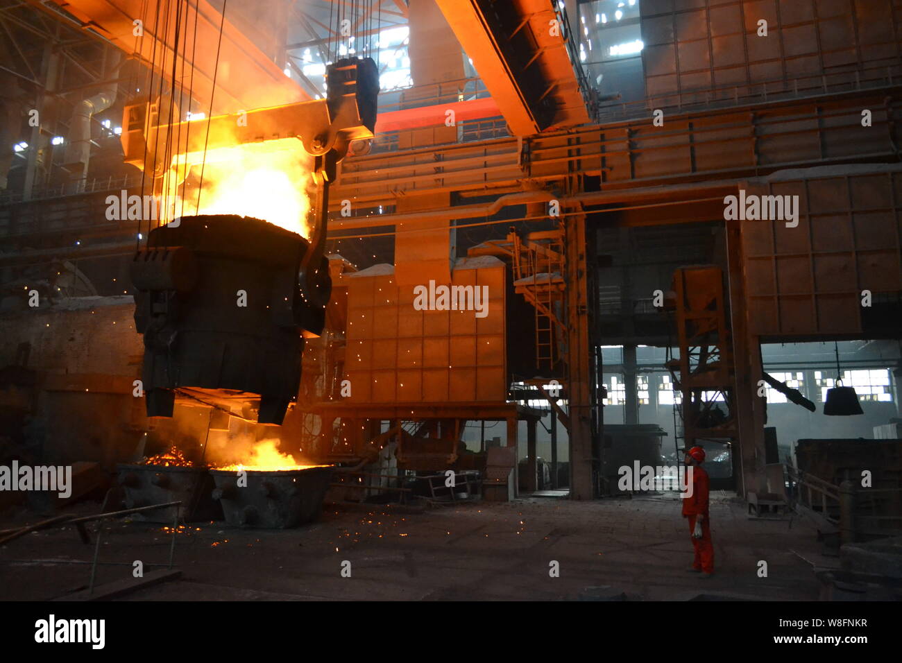 --FILE--A Chinese worker surveys the production of steel next to a ...