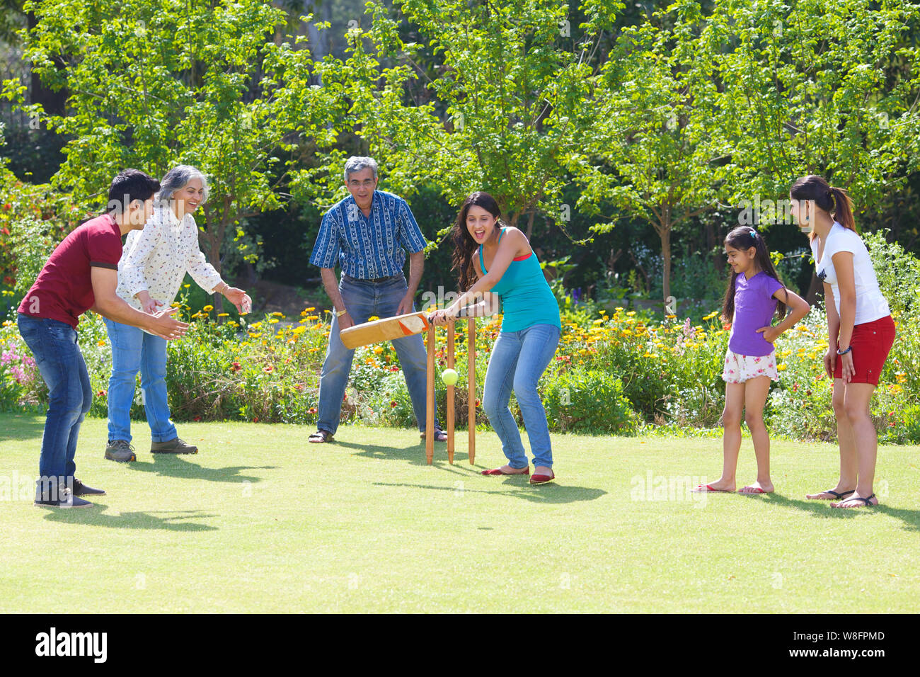 Family playing cricket in lawn Stock Photo - Alamy