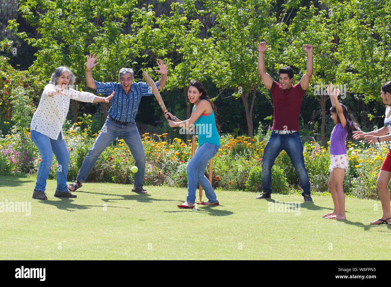 Family playing cricket in lawn Stock Photo - Alamy