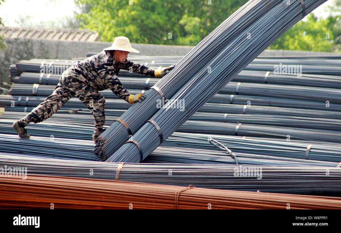 --FILE--A Chinese worker adjusts bundles of reinforcing steel rods ...