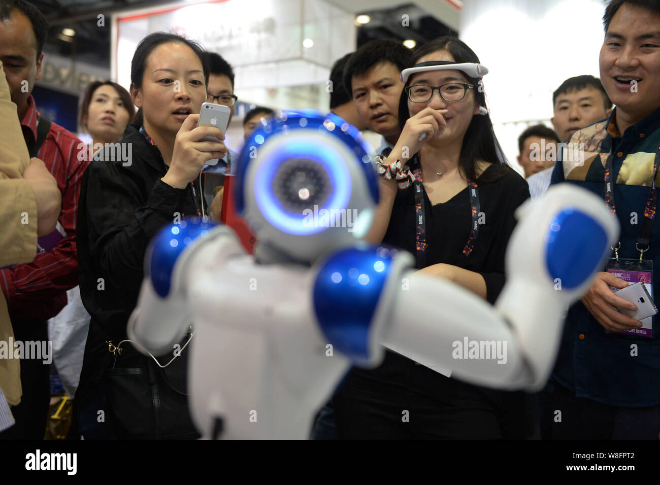 A Chinese visitor, second right, uses her brain wave to control a ...