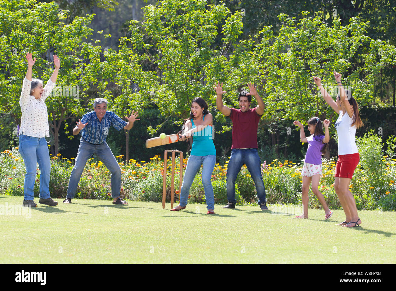 Family playing cricket in lawn Stock Photo - Alamy