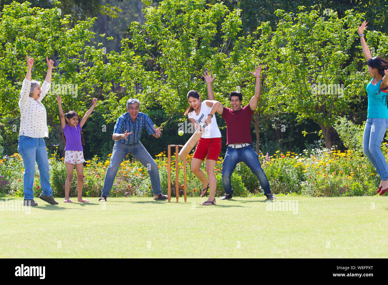 Family playing cricket in lawn Stock Photo - Alamy