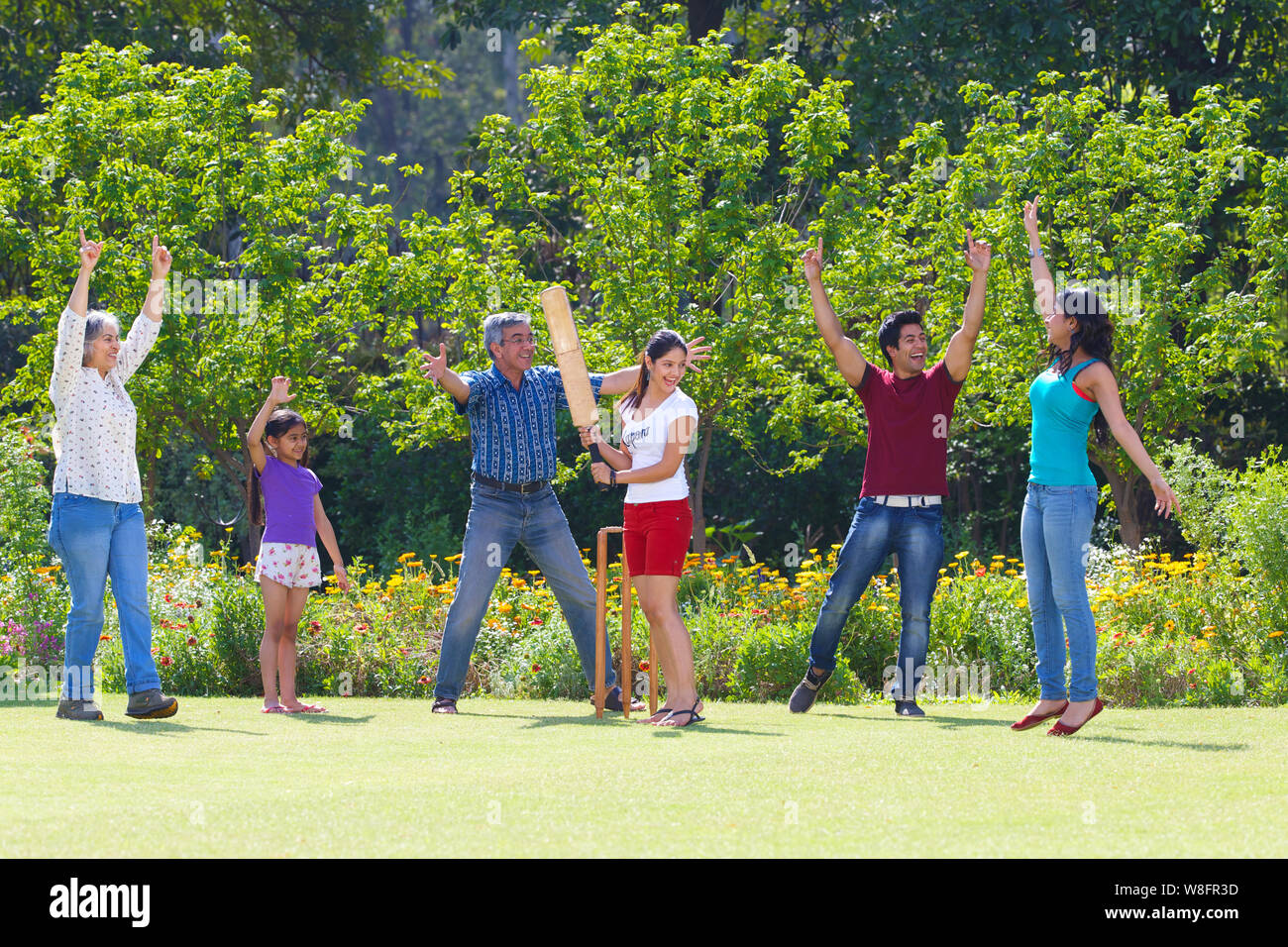 Family playing cricket in lawn Stock Photo - Alamy