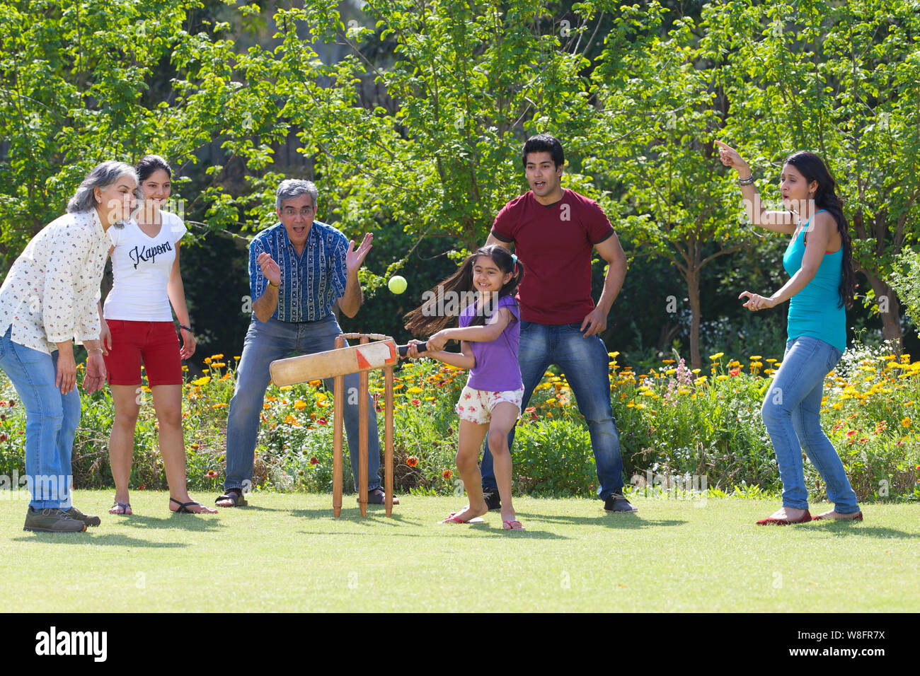 Family playing cricket in lawn Stock Photo - Alamy