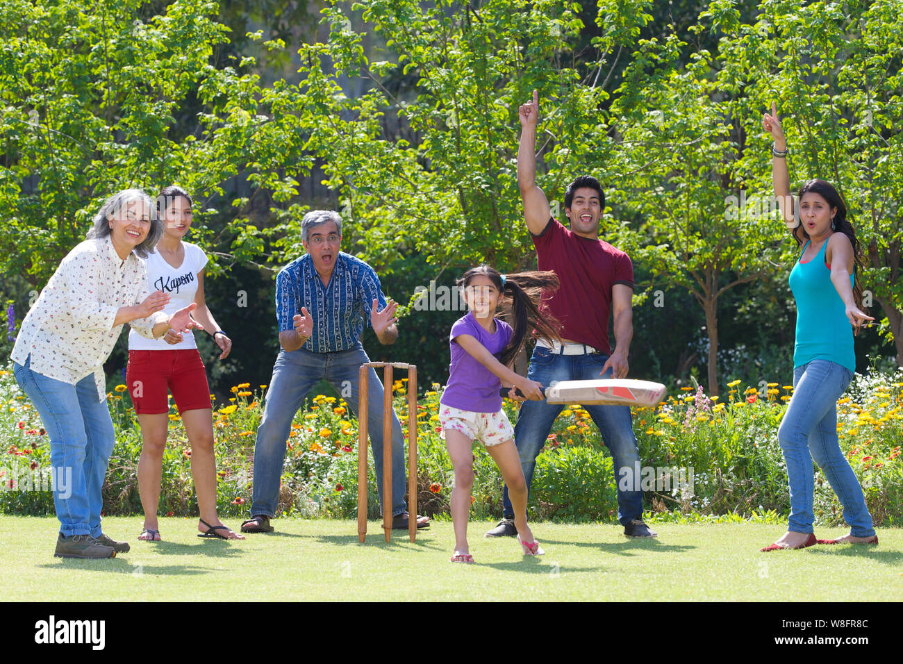 Family playing cricket in lawn Stock Photo - Alamy