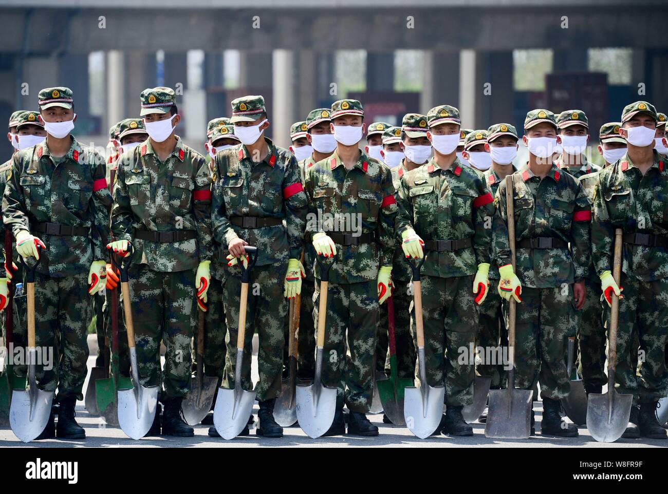 Chinese paramilitary policemen wearing face masks stand by for rescue ...