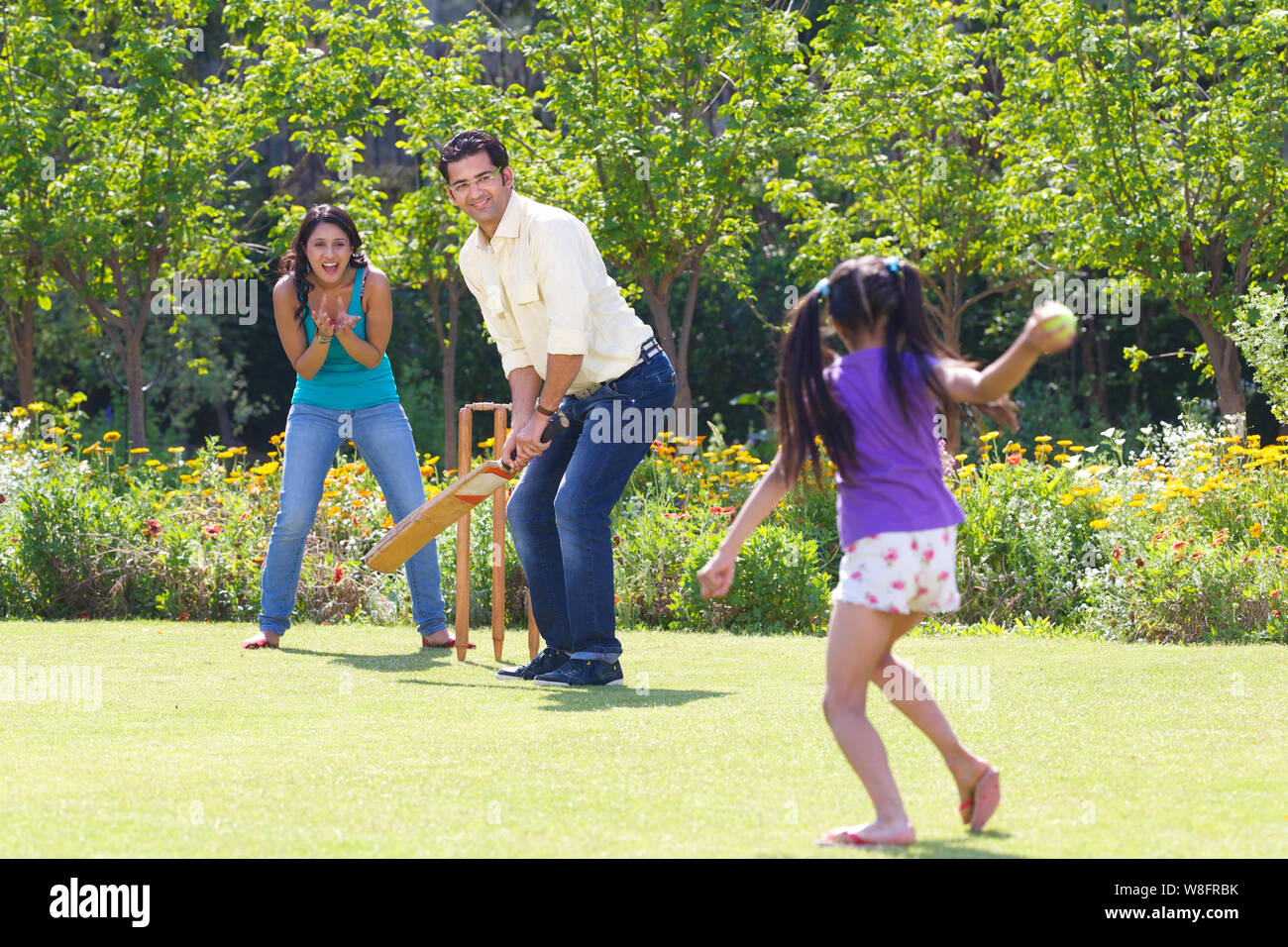 Family playing cricket in lawn Stock Photo - Alamy