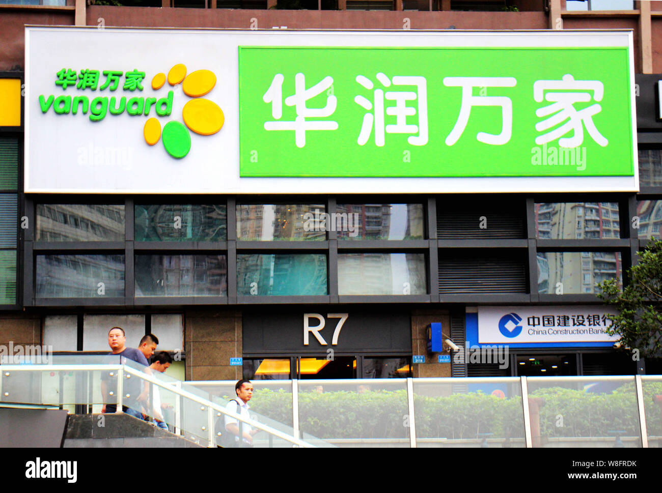 --FILE--Pedestrians walk past a China Resources Vanguard supermarket in ...