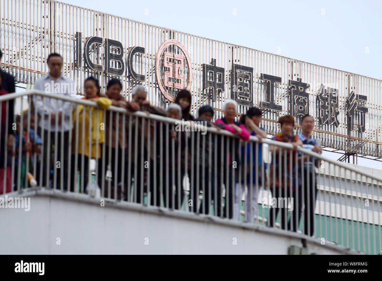 --FILE--Chinese pedestrians look down from a footbridge in front of a ...