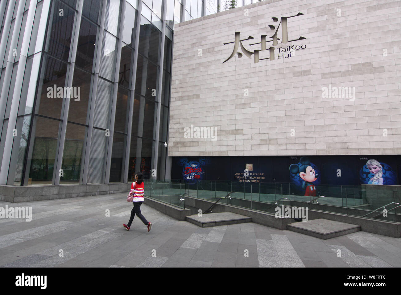 --FILE--A pedestrian walks past the Taikoo Hui shopping mall in ...