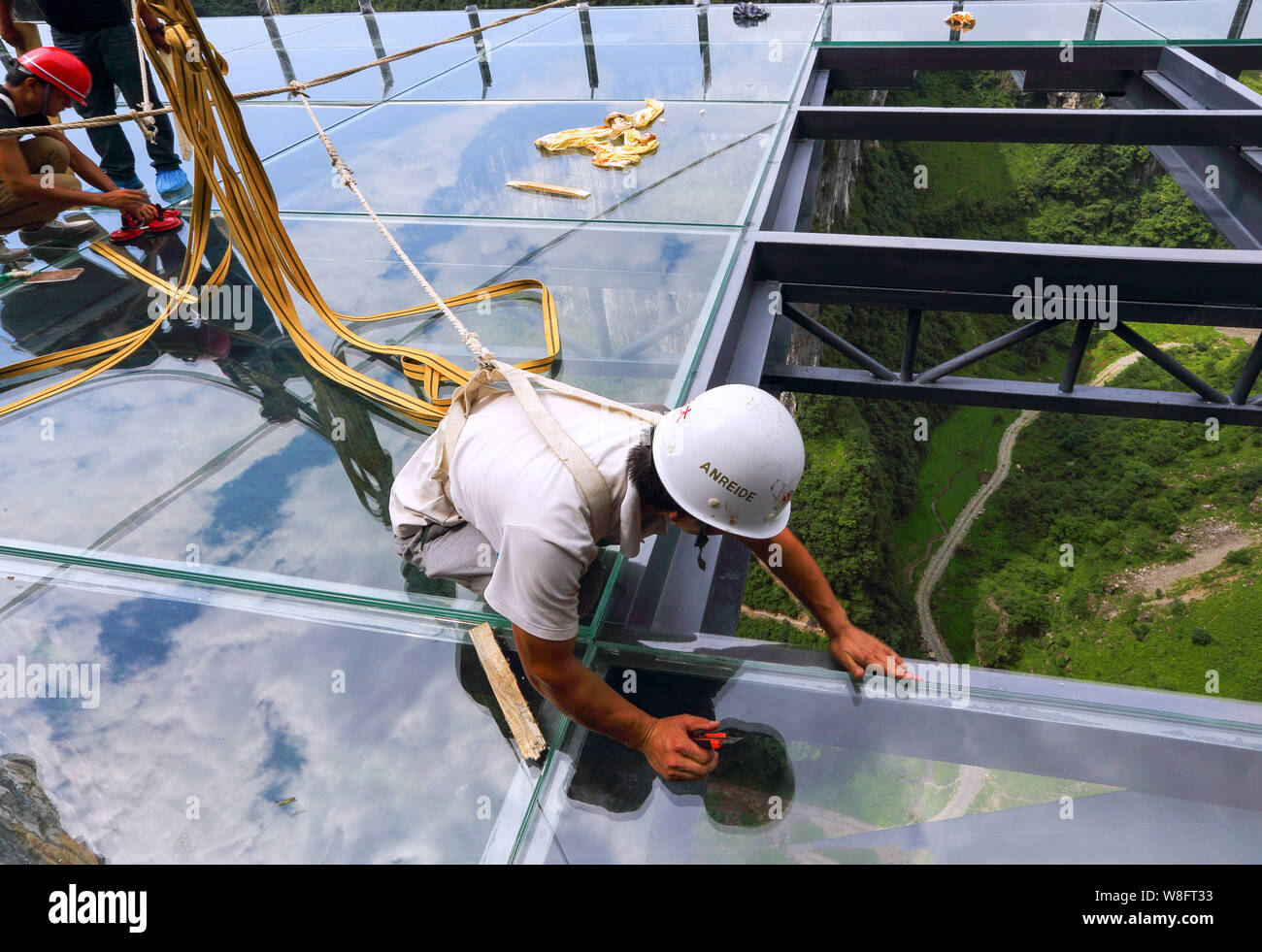 Chinese workers install the final piece of glass on the Asia's largest ...