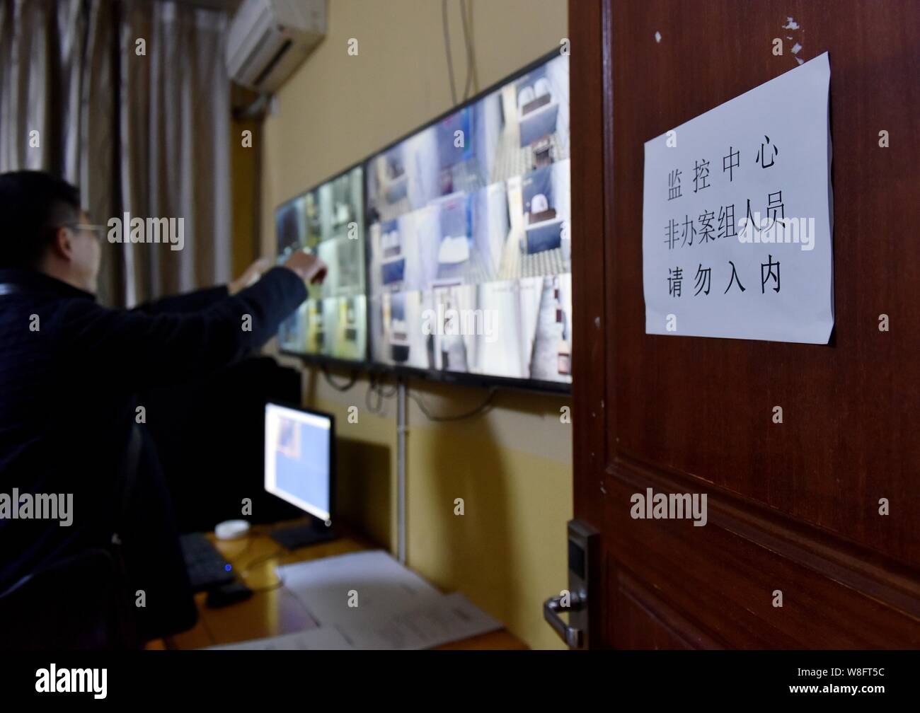 Security guards watch screens in a monitor and control room at a ...