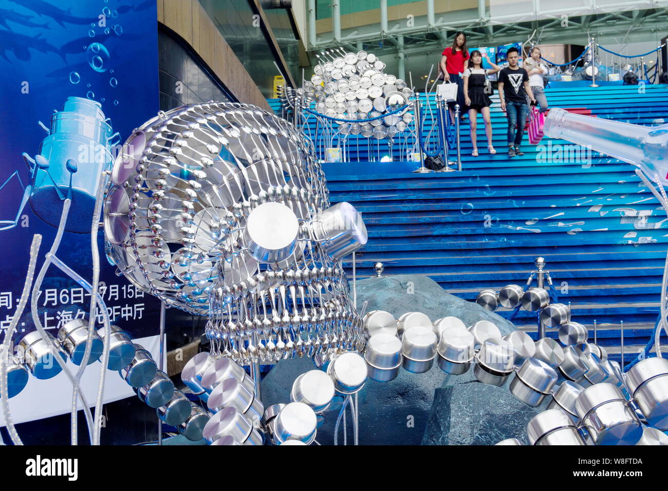 Pedestrians walk past giant octopus and fish made out of cooking ...