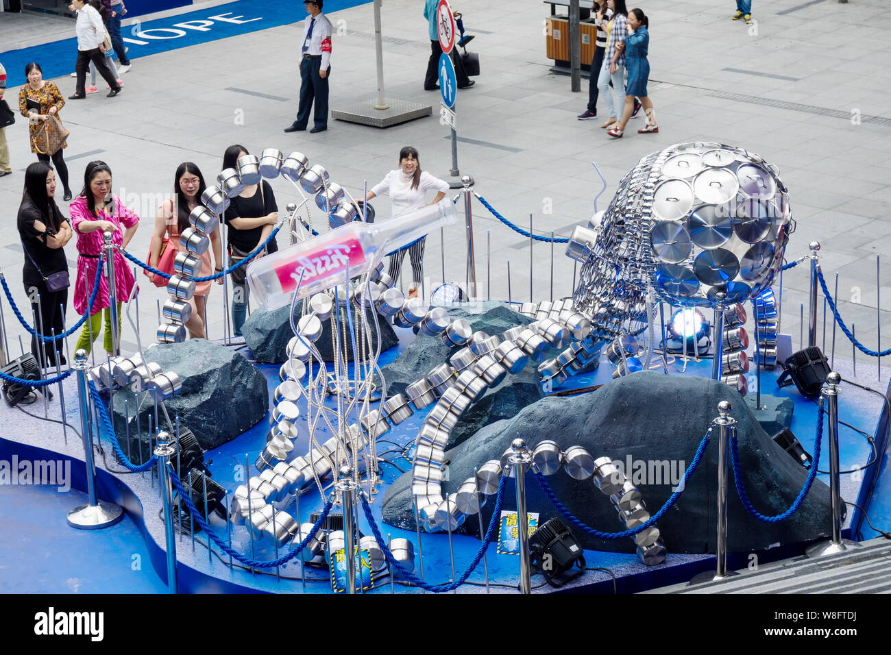 Pedestrians look at a giant octopus made out of cooking utensils on ...