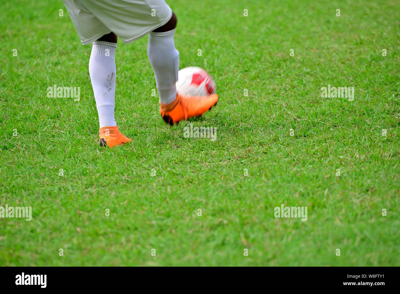 Soccer player is running to kick soccer ball Stock Photo - Alamy