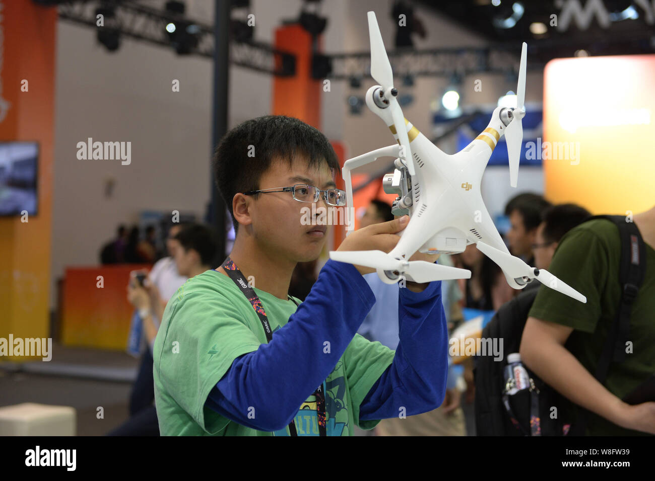 --FILE--A Chinese visitor looks at a camera-equipped unmanned aerial ...