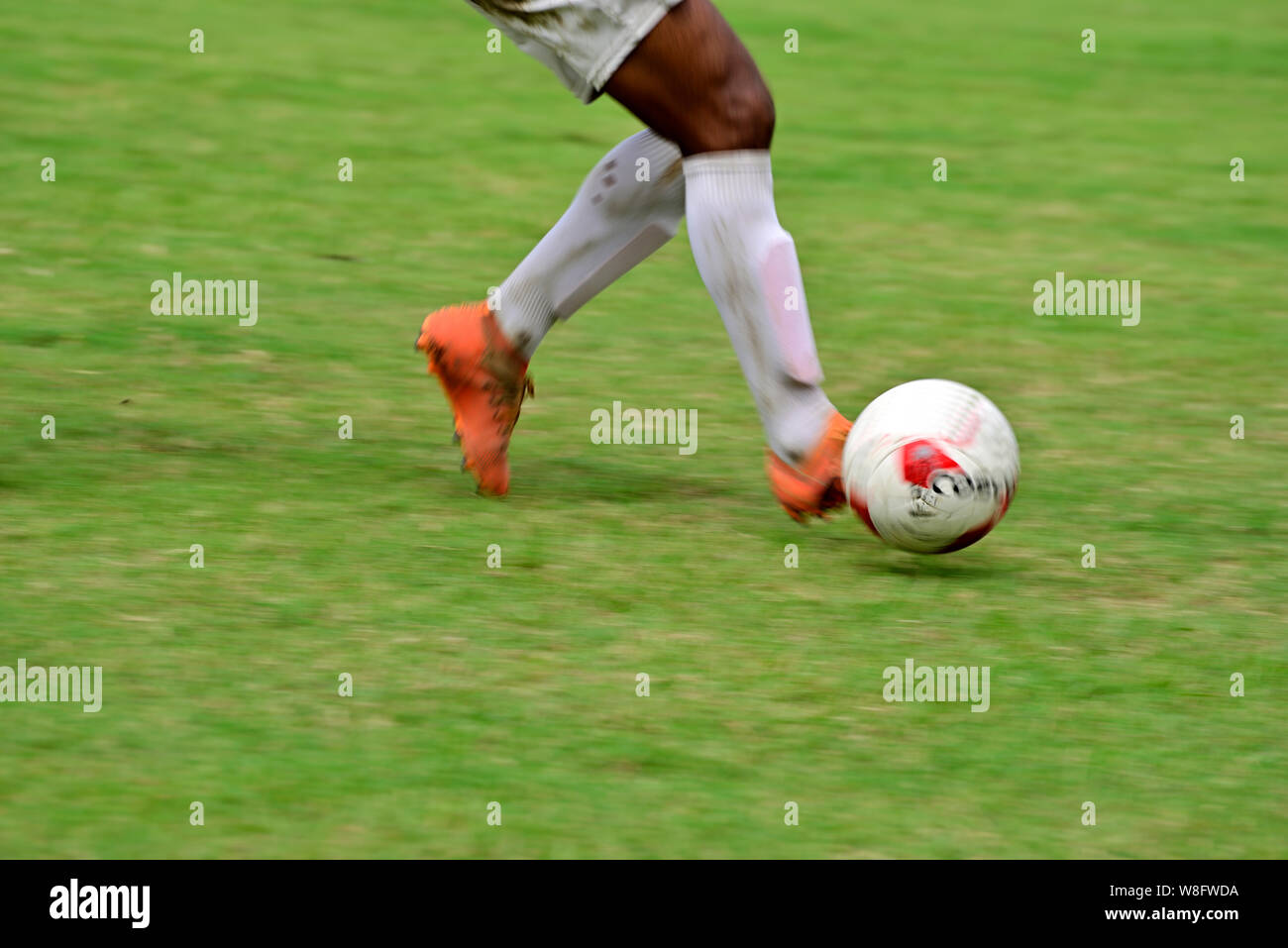 Soccer player is running to kick soccer ball Stock Photo - Alamy