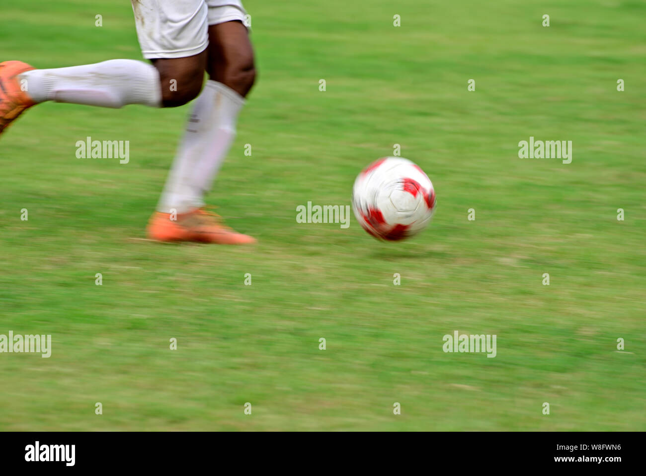 Soccer player is running to kick soccer ball Stock Photo - Alamy