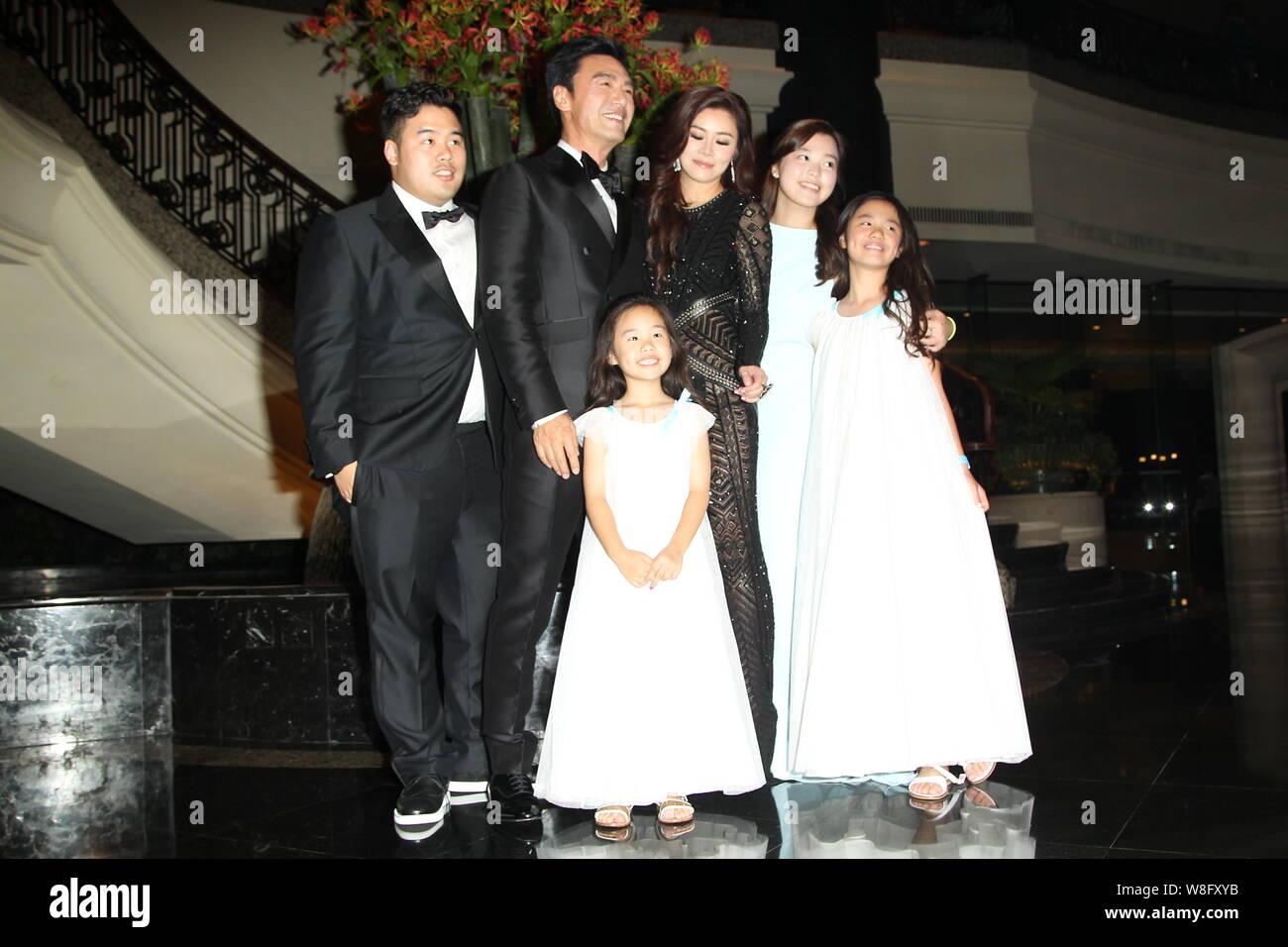 Hong Kong actor Kenny Bee, second left, his wife Fan Jiang and their children pose as they ...