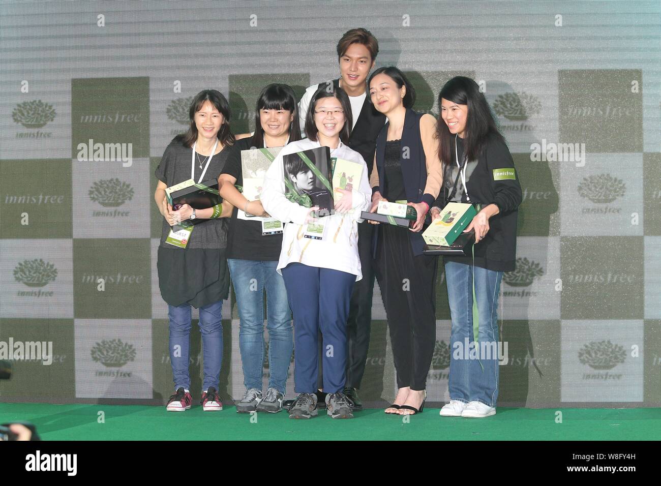 South Korean singer and actor Lee Min-ho, back, poses with fans at a ...