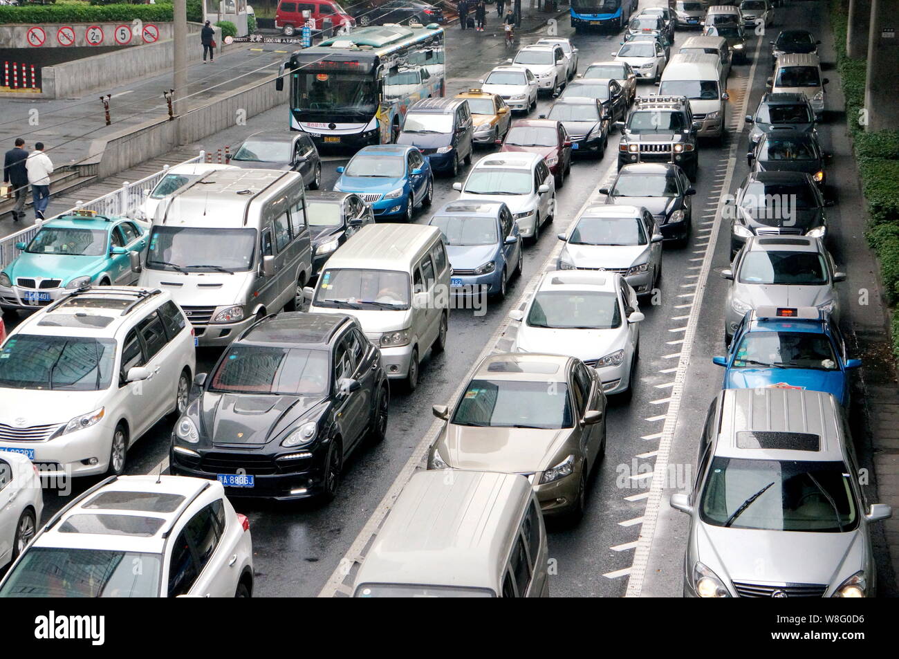 Masses of vehicles move slowly in a traffic jam on a road during the ...