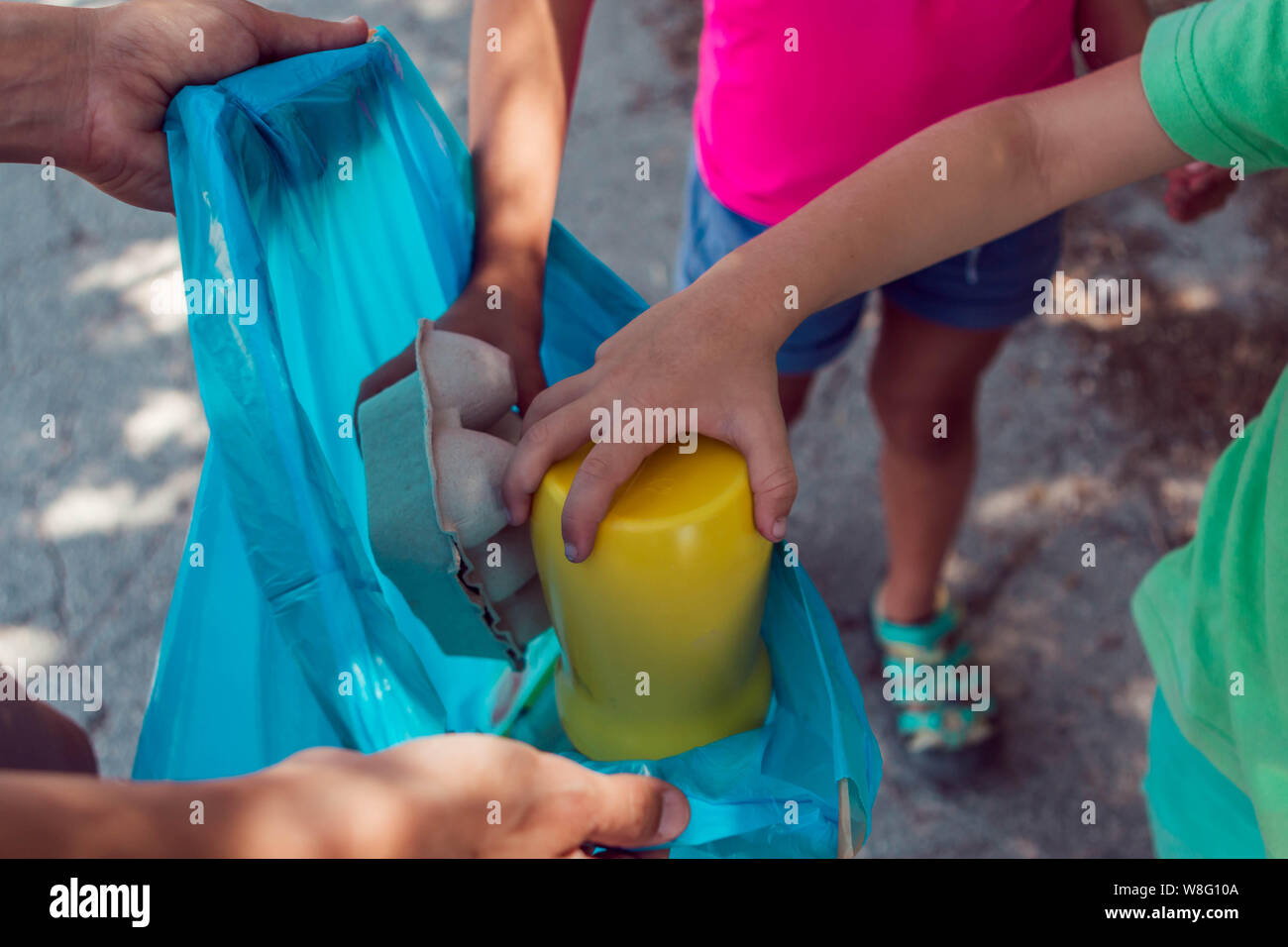 Closed up of kids hands with their mother collection garbage in the ...