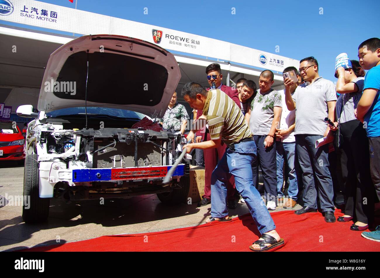 A visitor whacks the front bumper of a promoter's car with a 1-meter ...